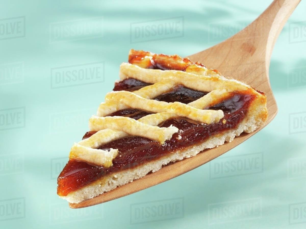 Piece of Linzer torte (lattice tart) on cake server - Stock Photo ...
