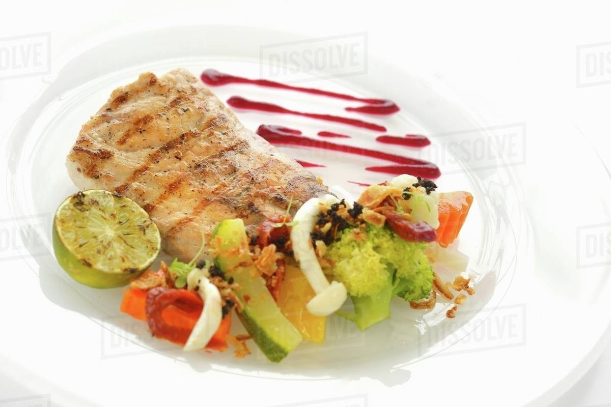 Grilled fish fillet with a vegetable salad, chilli sauce and lime ...