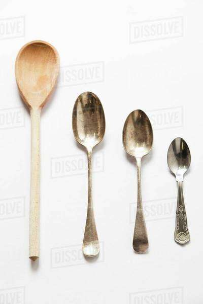 Wooden spoon and different sized metal spoons - Royalty-free Stock ...