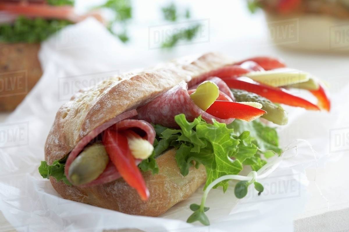 Ciabatta with salami, pepper, gherkins and baby corn cobs - Royalty ...