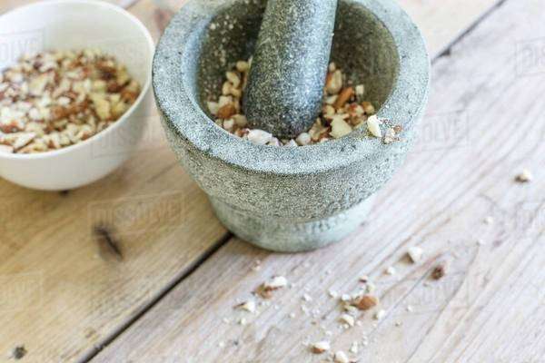 Nuts being ground in a mortar - Royalty-free Stock Photo | Dissolve