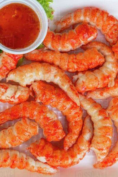 Prawn-shaped snacks with a spicy dip - Stock Photo - Dissolve
