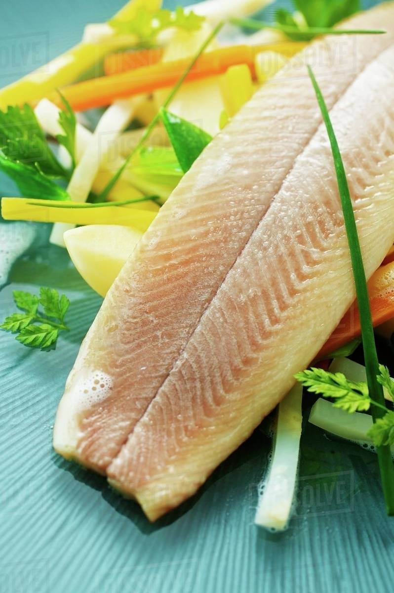Poached trout with root vegetables and herbs - Stock Photo - Dissolve