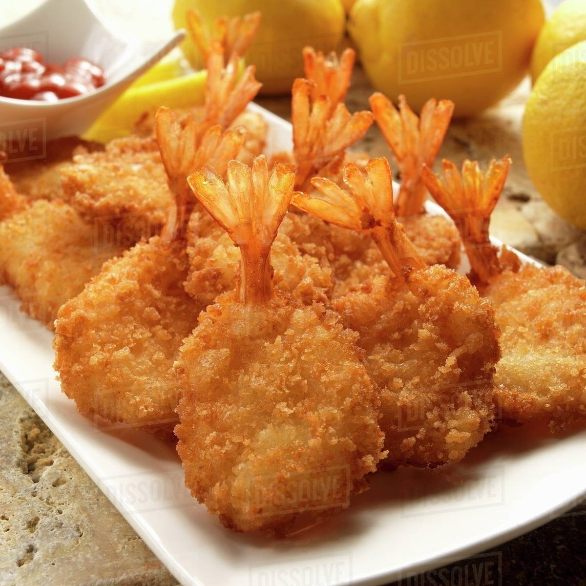 Breaded fried prawns with lemons - Royalty-free Stock Photo | Dissolve