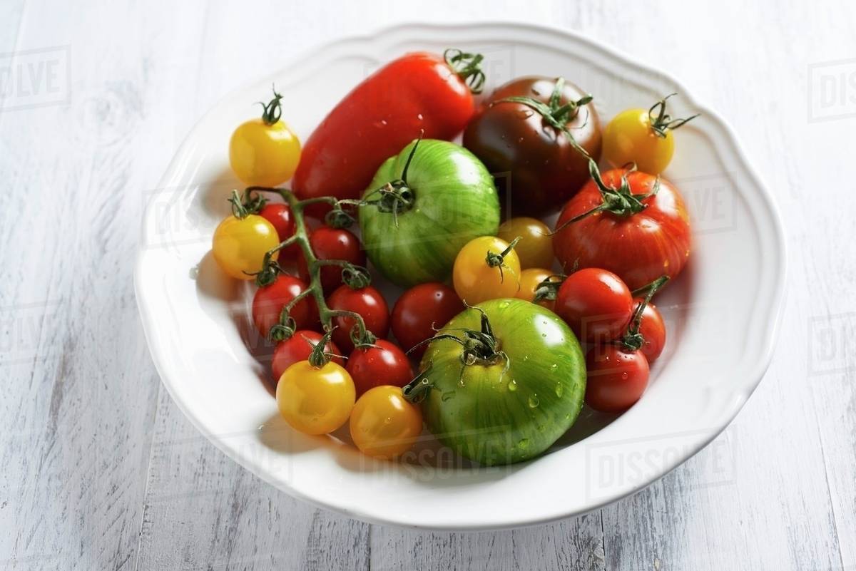 Various different coloured tomatoes on a white plate - Stock Photo ...