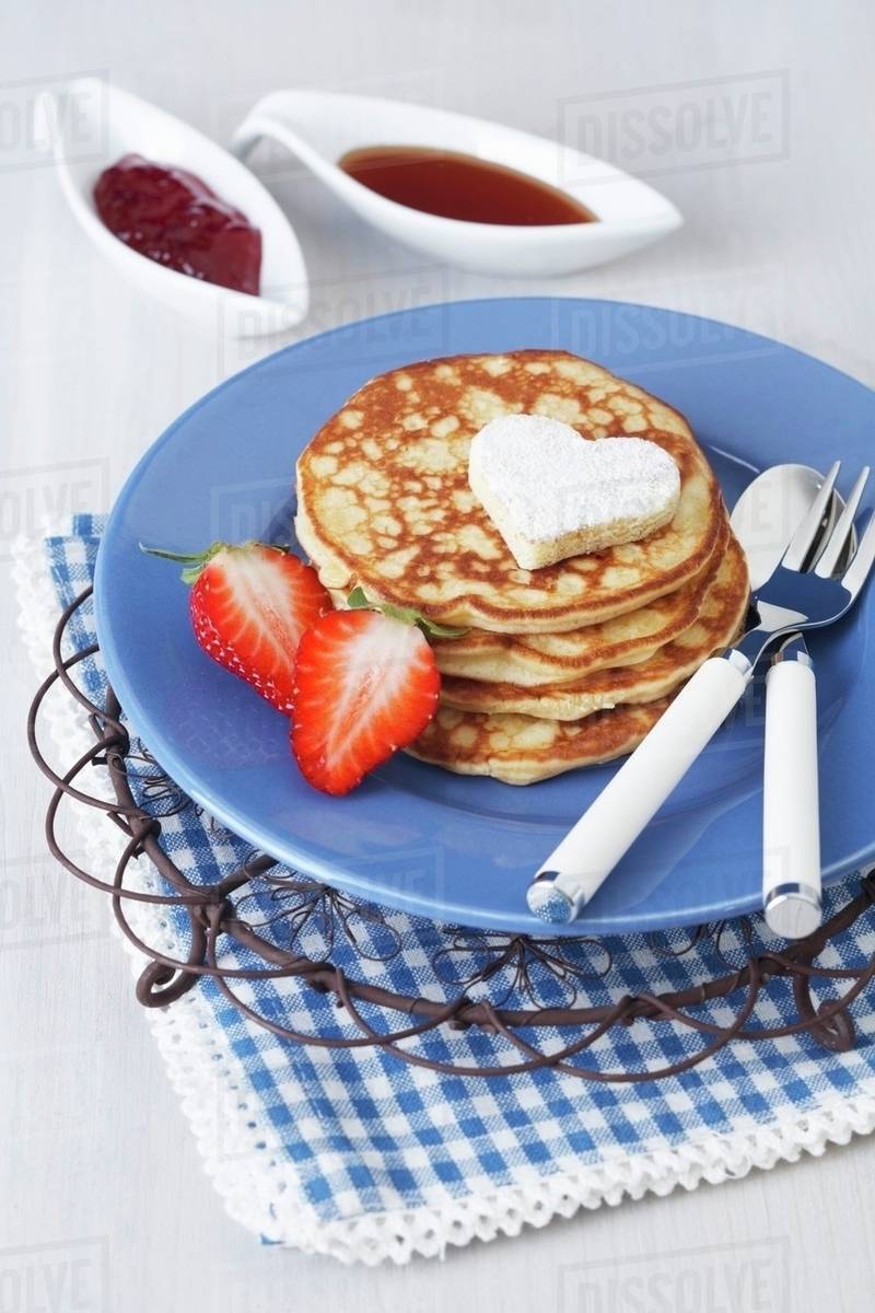 Dutch pannekoeken (pancakes) with icing sugar, maple syrup and jam ...