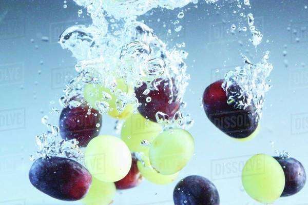 Grapes falling into water - Stock Photo - Dissolve