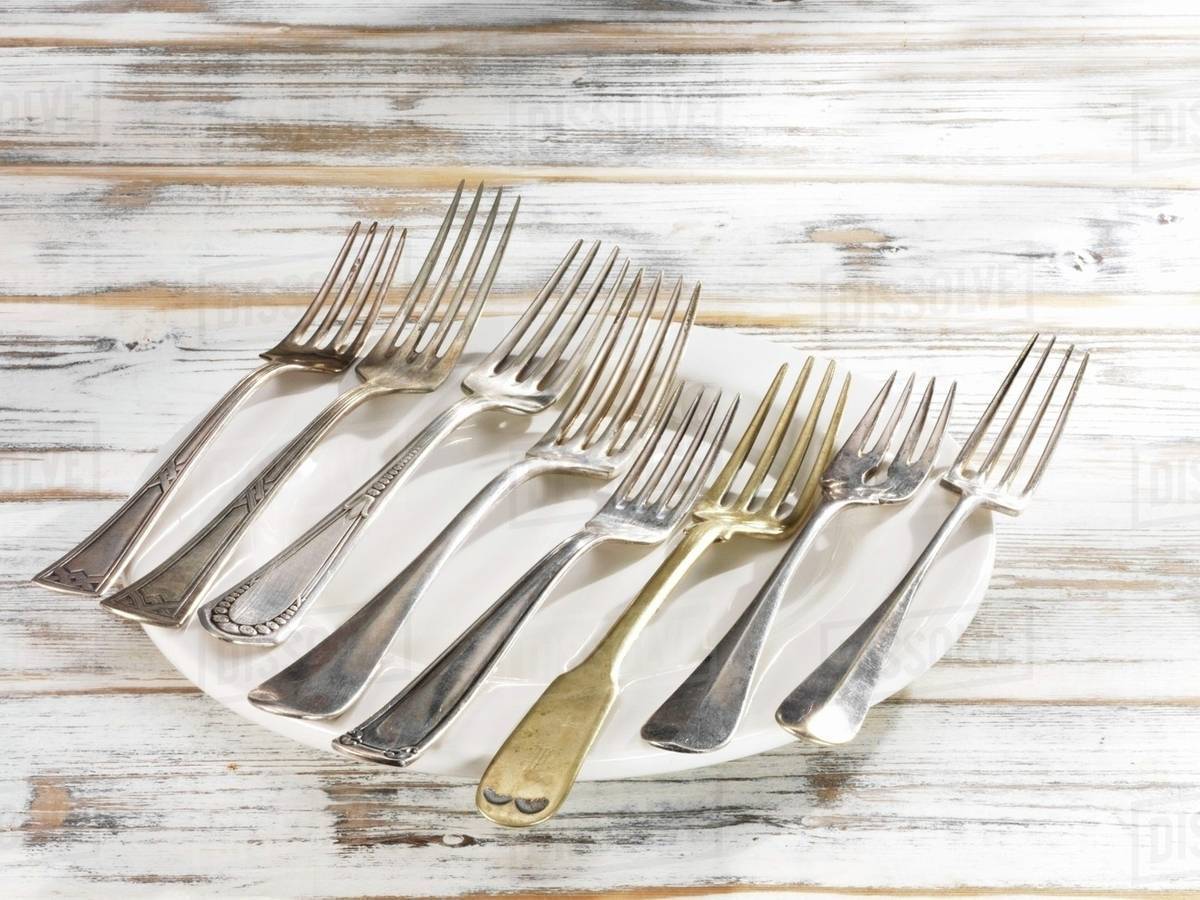 Eight forks in a line lying on a plate - Royalty-free Stock Photo ...