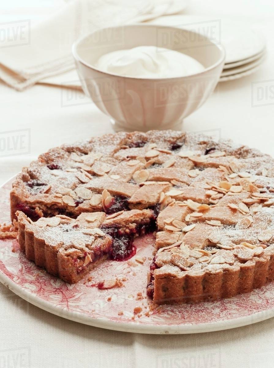 Linzer torte (nut and jam layer cake) with sliced almonds, partly ...