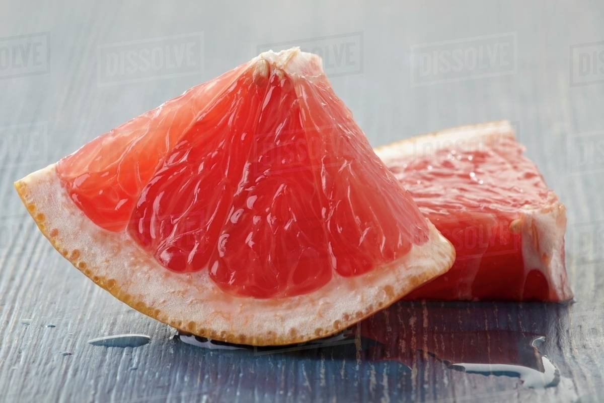 Two wedges of pink grapefruit - Royalty-free Stock Photo | Dissolve