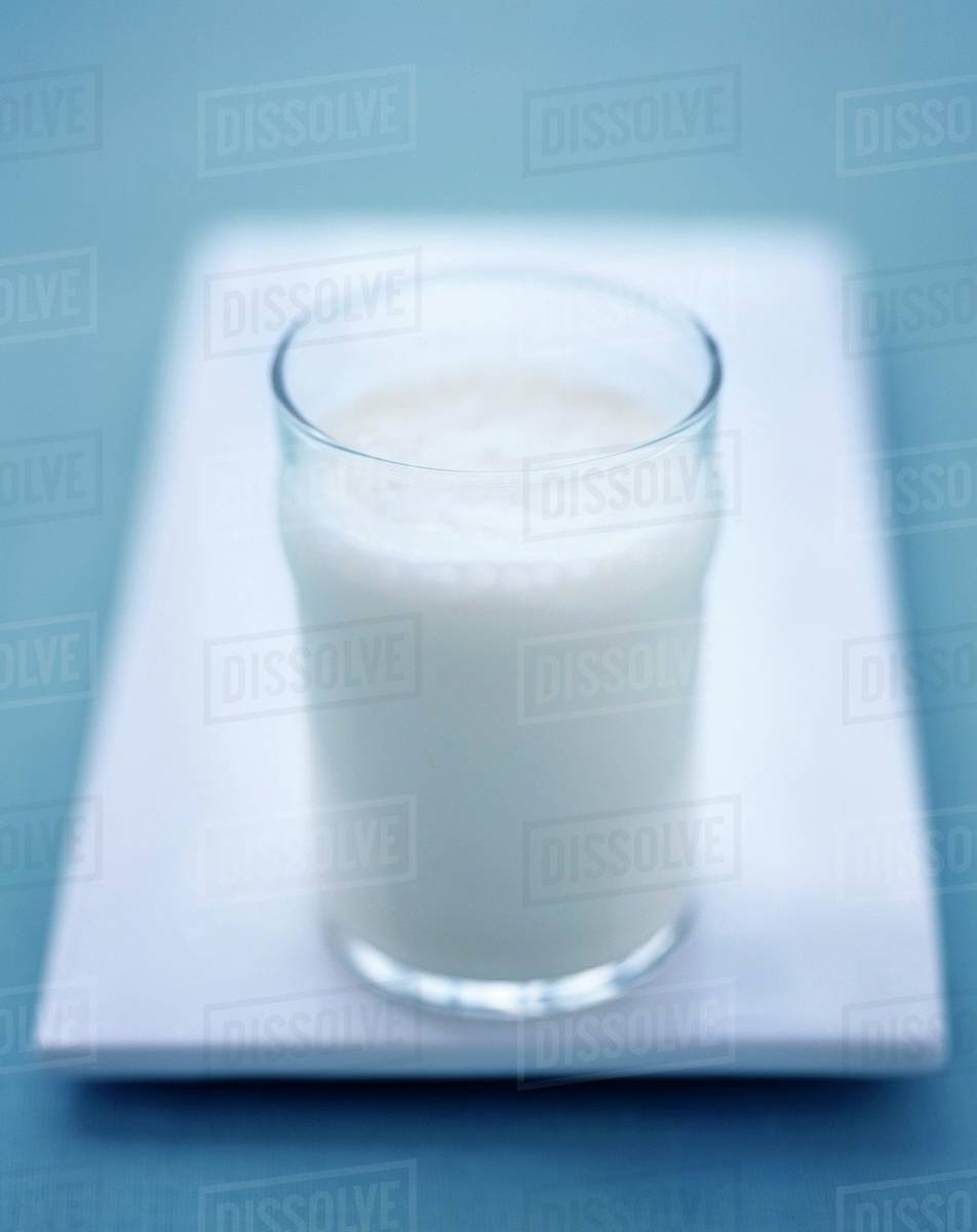 A glass of milk on a white serving platter - Stock Photo - Dissolve