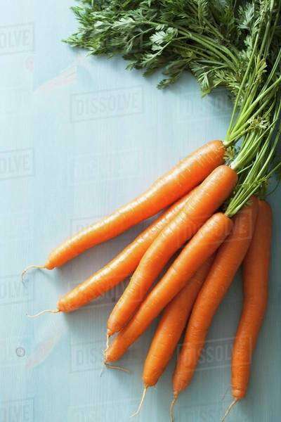 Fresh carrots on a pale blue surface - Royalty-free Stock Photo | Dissolve