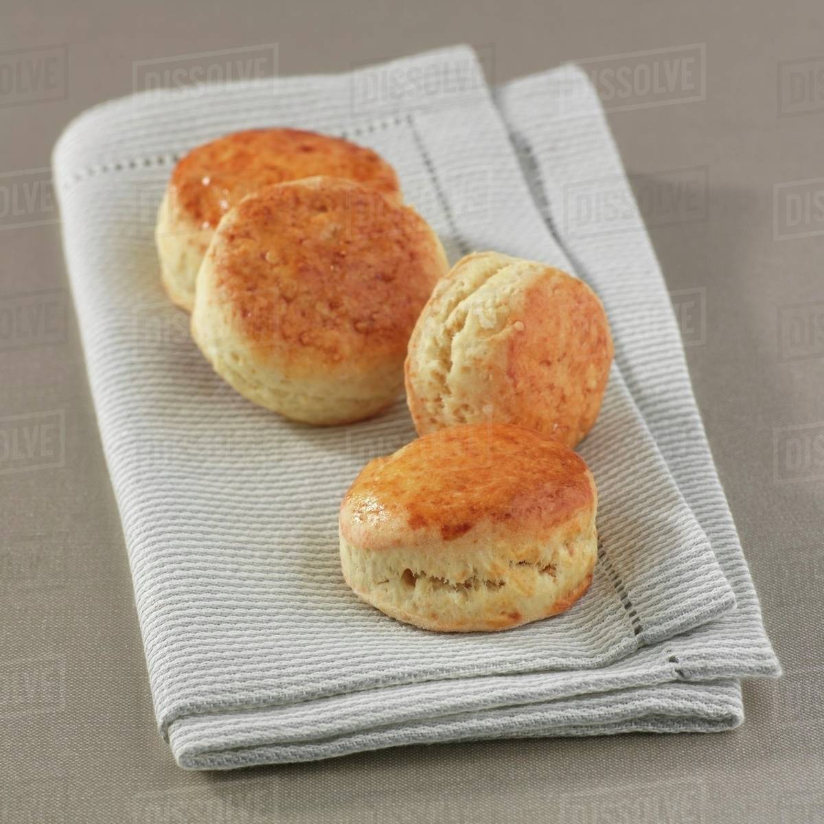 Four scones on a tea towel - Stock Photo - Dissolve
