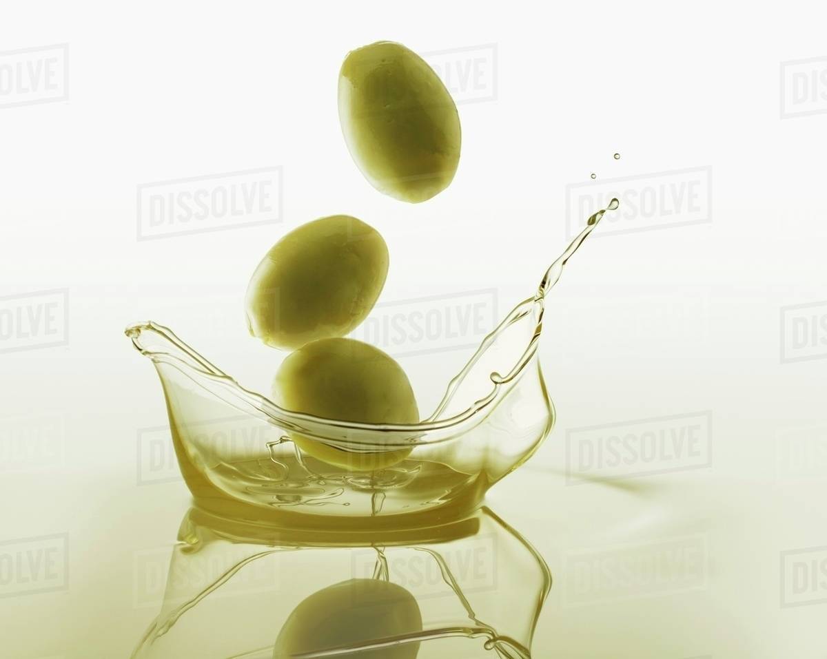 Olives falling into olive oil - Royalty-free Stock Photo | Dissolve