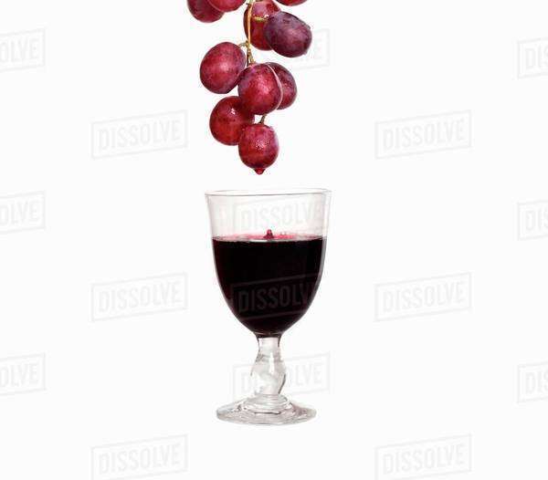 Red wine dripping from red grapes into wine glass - Royalty-free Stock ...