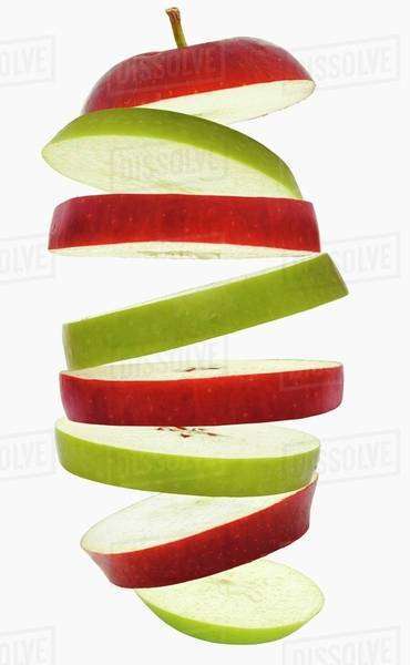 Flying slices of red and green apple - Royalty-free Stock Photo | Dissolve