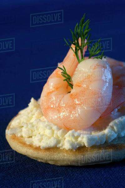 A blini topped with cream cheese and prawns - Stock Photo - Dissolve