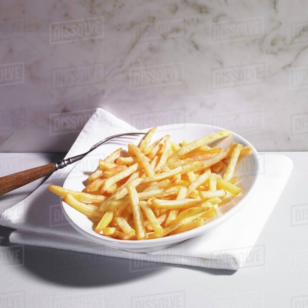 A plate of chips with a fork - Royalty-free Stock Photo | Dissolve