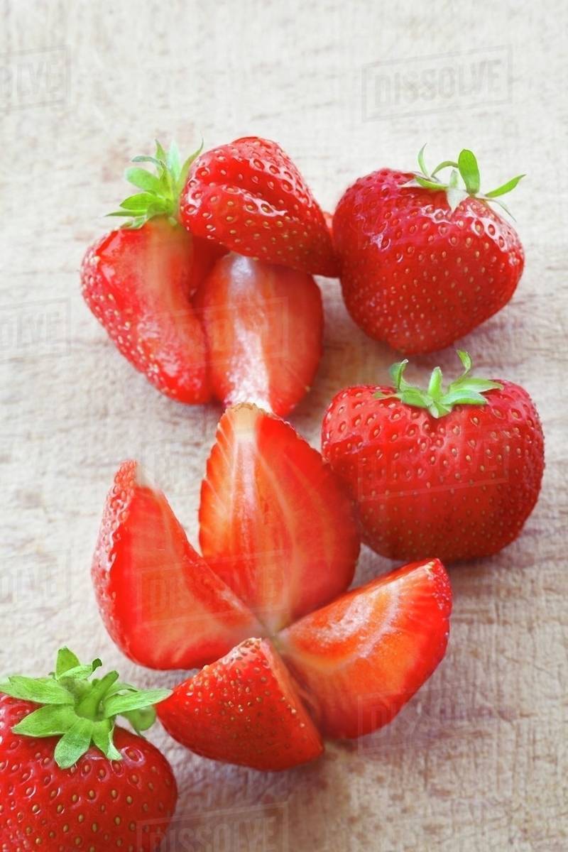 Strawberries, whole and quartered - Royalty-free Stock Photo | Dissolve