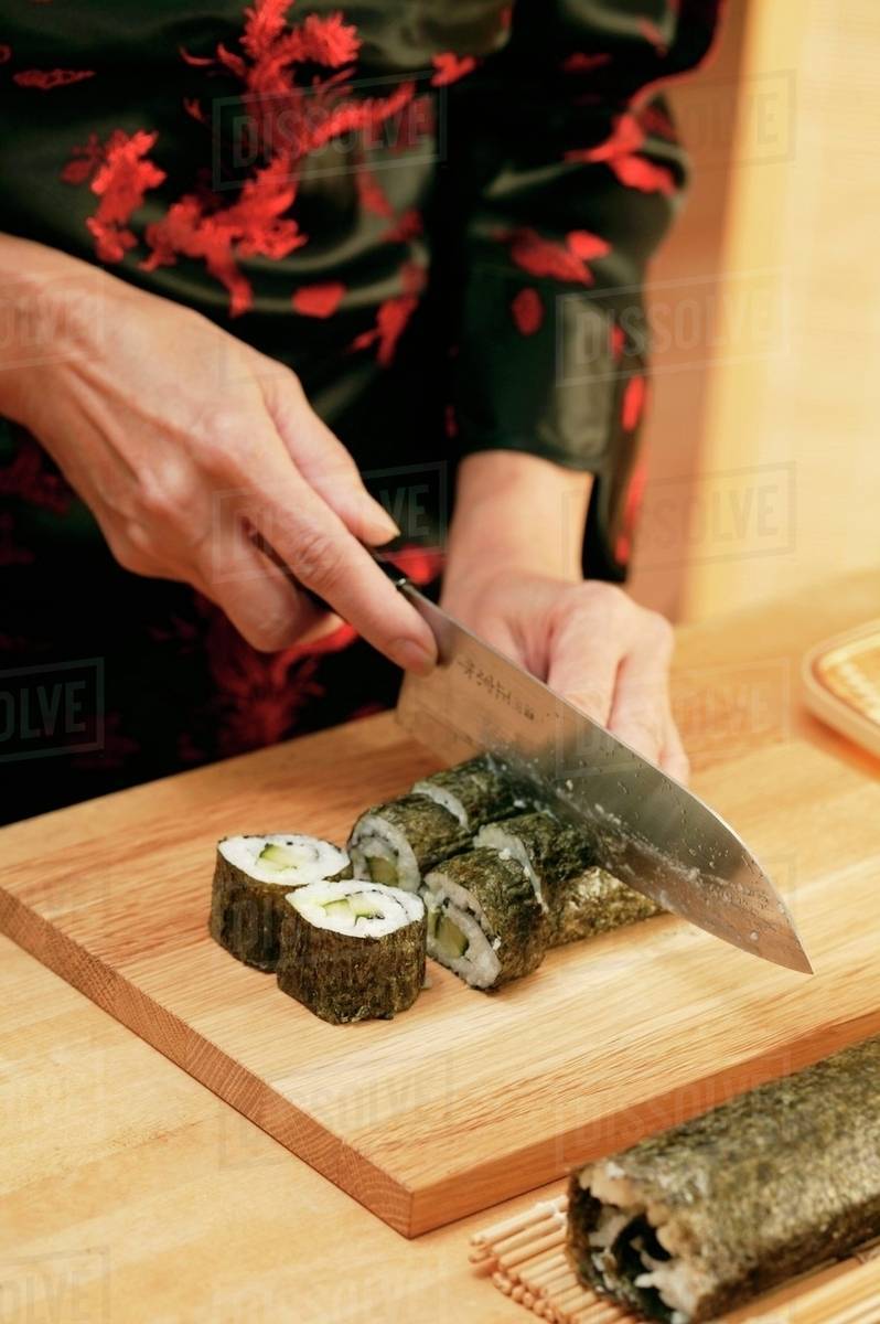 Cutting rolled sushi into pieces - Royalty-free Stock Photo | Dissolve