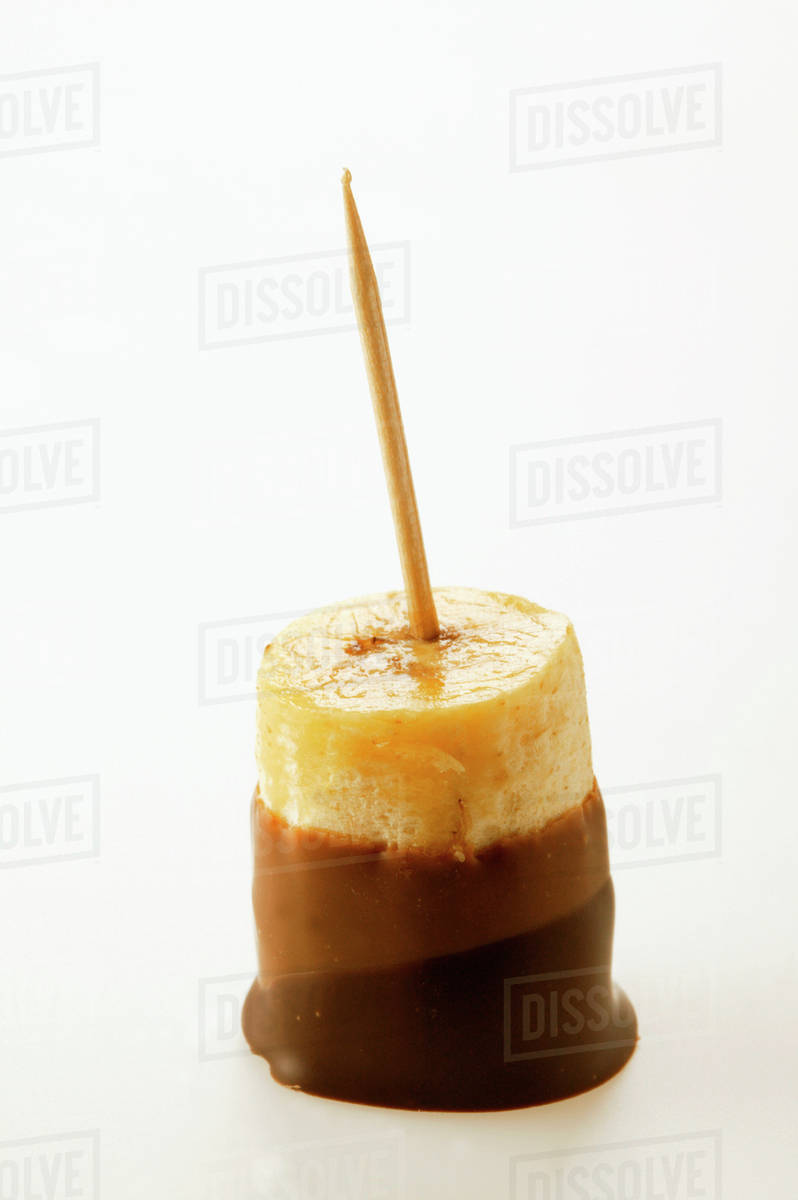 Chocolate-coated banana on toothpick - Stock Photo - Dissolve
