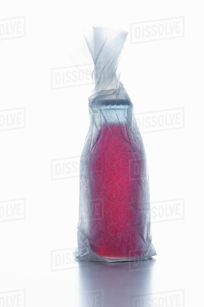 A bottle of red liquid wrapped in paper - Royalty-free Stock Photo ...