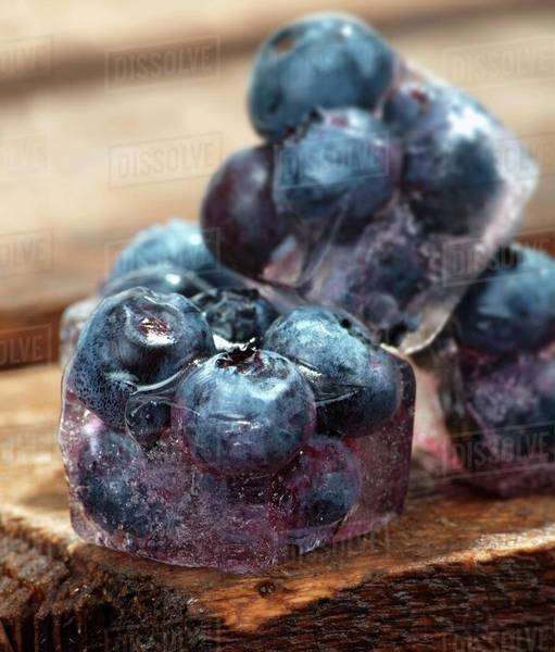 Ice cubes with blueberries on a wooden table - Royalty-free Stock Photo ...