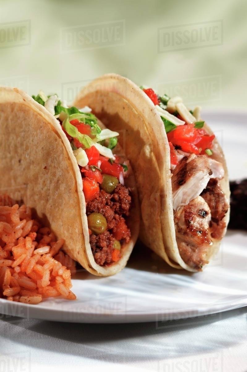 Two Taco; Both Have a Soft Shell Layered Inside a Hard Shell; One with ...