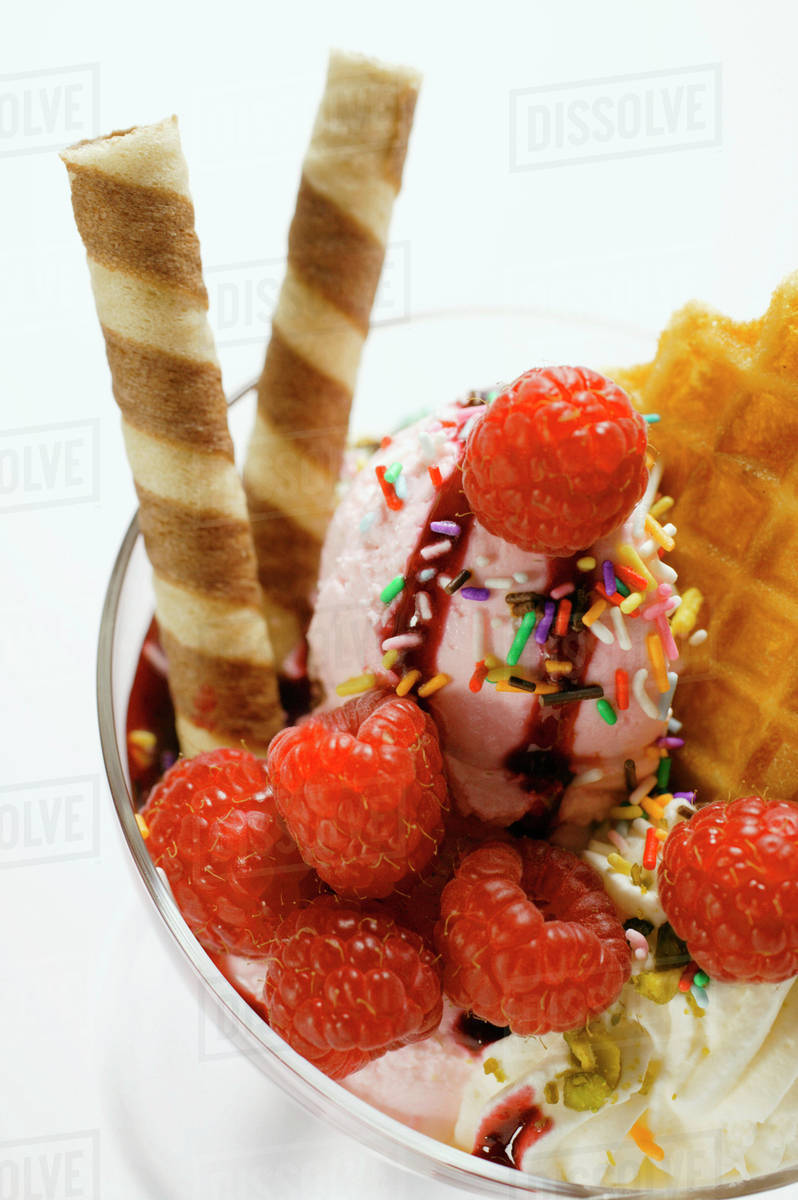 Sundae with raspberry ice cream, cream, wafers & sprinkles - Royalty ...