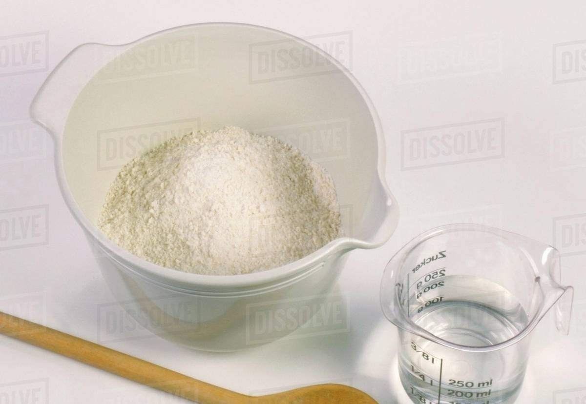 Flour in a bowl and water in a measuring jug - Royalty-free Stock Photo ...