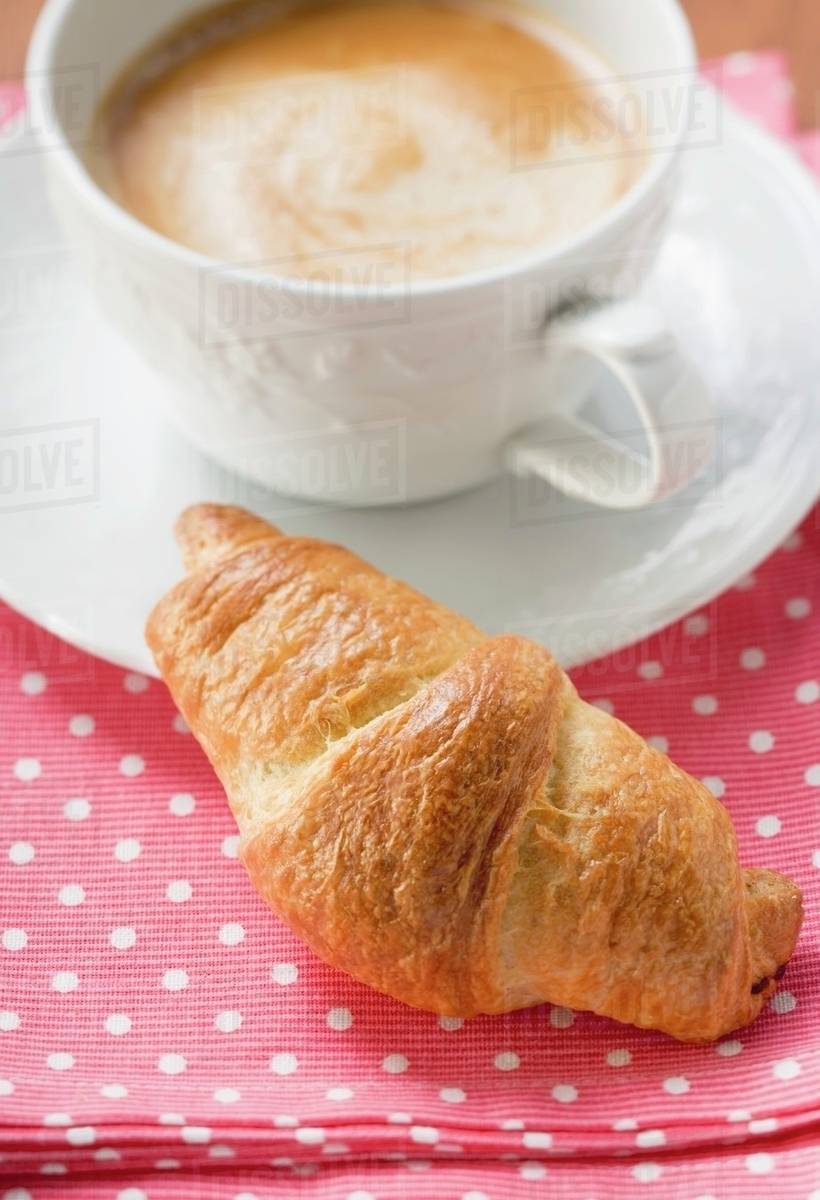 A croissant with a cup of cappuccino - Royalty-free Stock Photo | Dissolve