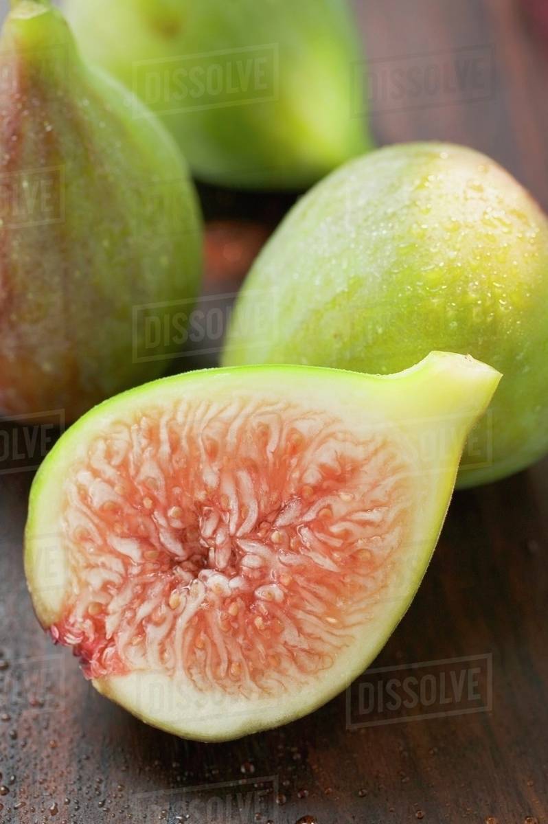 Three whole figs and one half fig (close-up) - Stock Photo - Dissolve