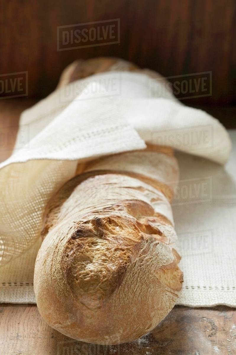 Rustic French stick in white cloth - Royalty-free Stock Photo | Dissolve