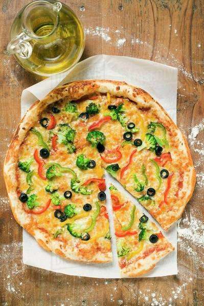 American-style vegetable pizza, a slice cut, olive oil - Royalty-free ...