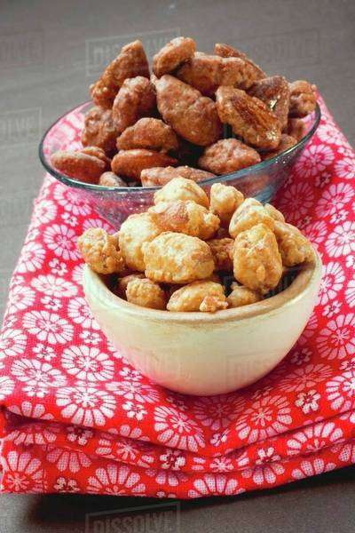 Assorted nuts to nibble in bowls on patterned cloth - Royalty-free ...