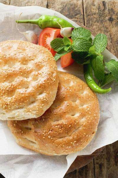 Sesame flatbread, tomato, mint, chilli, garlic on paper - Stock Photo ...