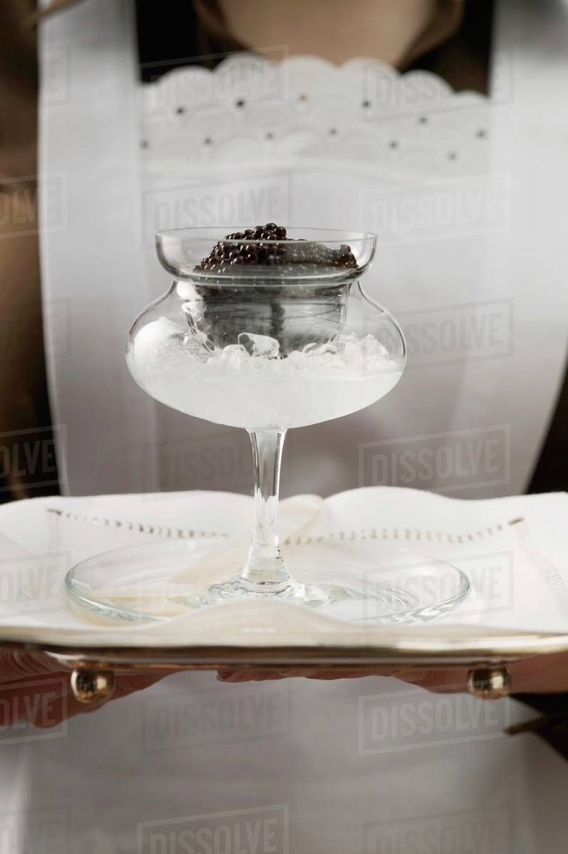 Chambermaid serving caviar in stemmed glass on tray - Royalty-free ...