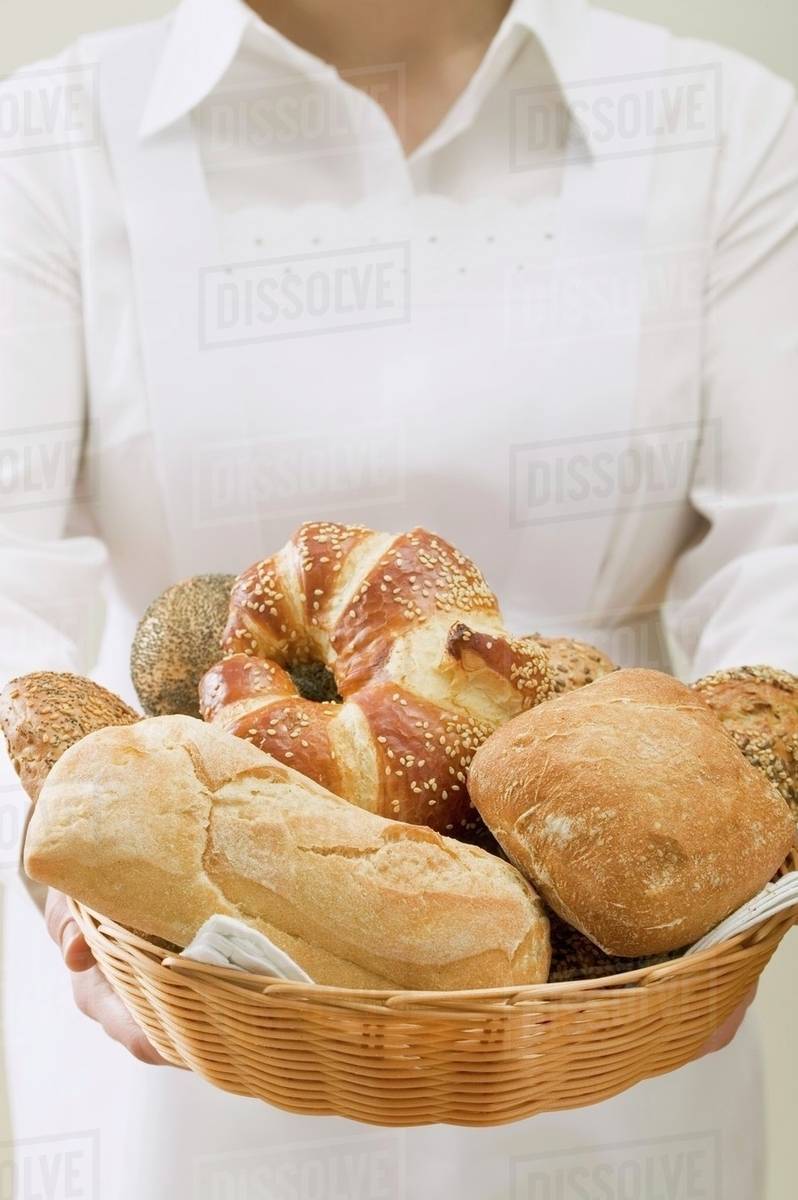 Chambermaid serving assorted bread rolls in bread basket - Stock Photo ...