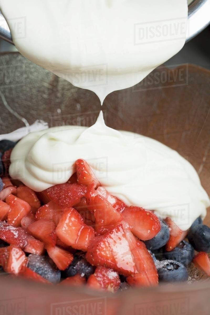 Pouring cream over berries - Royalty-free Stock Photo | Dissolve
