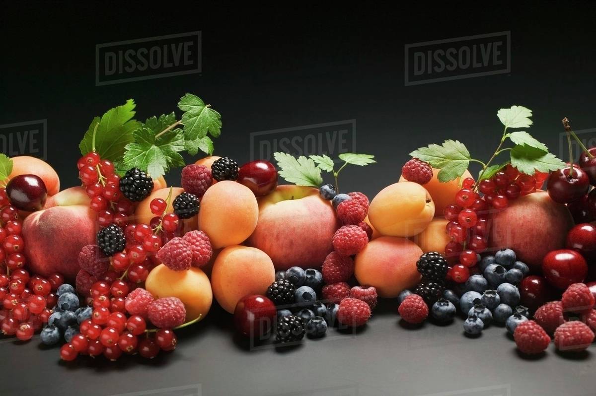 Fruit still life with stone fruit, berries and leaves - Stock Photo ...