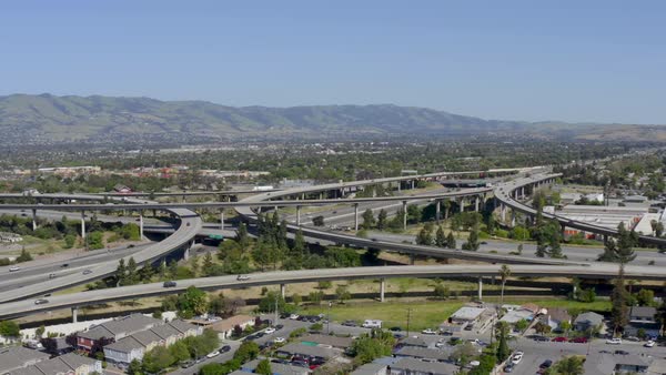 Drone shot of traffic moving on highway in city with mountain range in ...
