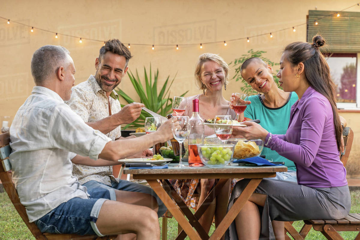 Happy friends laughing with big smile around the table in a summer ...