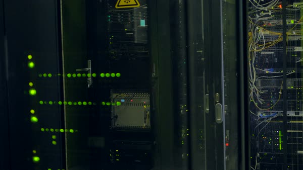 Blinking lights and data cables seen through network cabinets doors ...