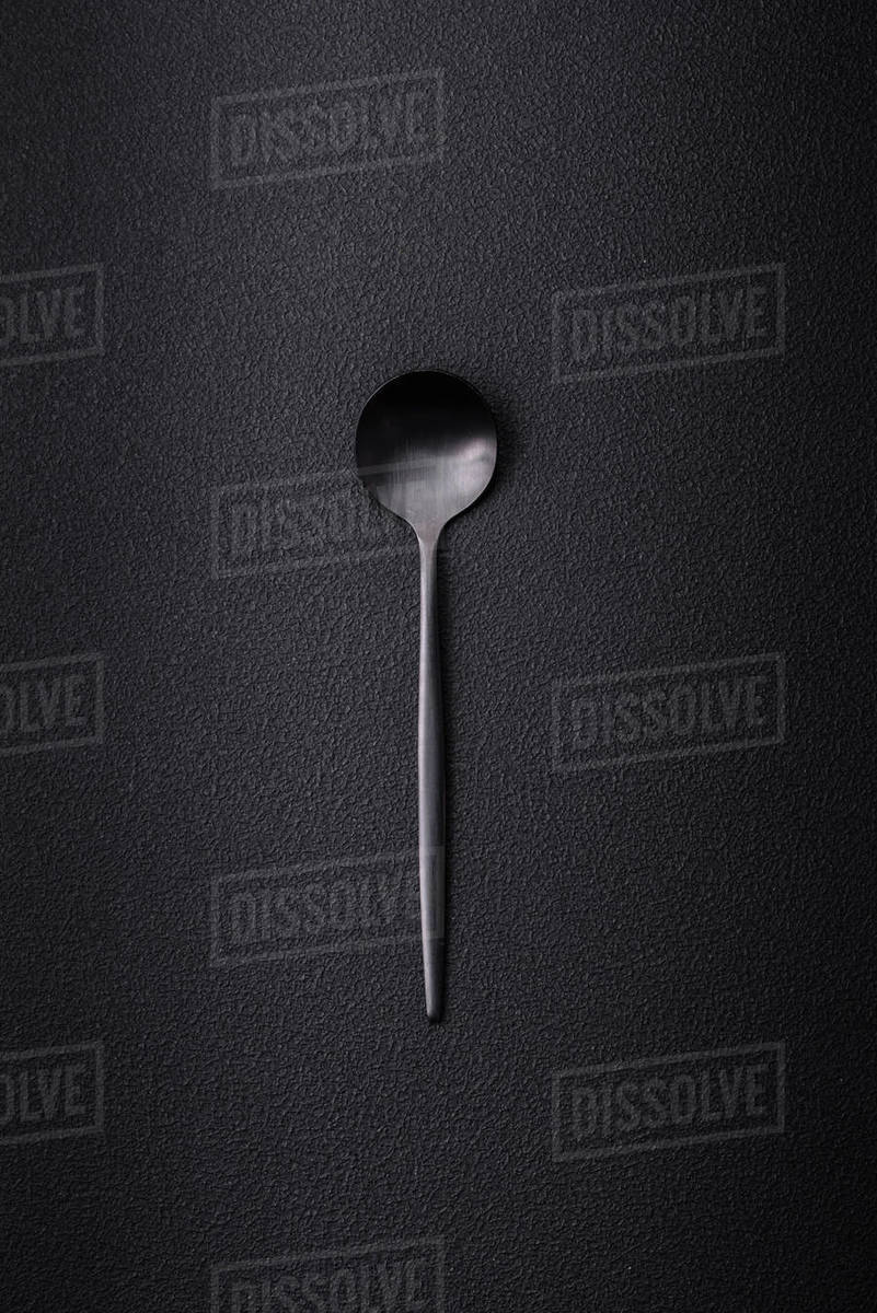 Empty metal spoon on dark textured concrete background. Cutlery ...