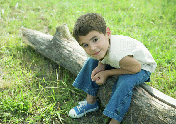 Boy sitting on log - Royalty-free Stock Photo | Dissolve