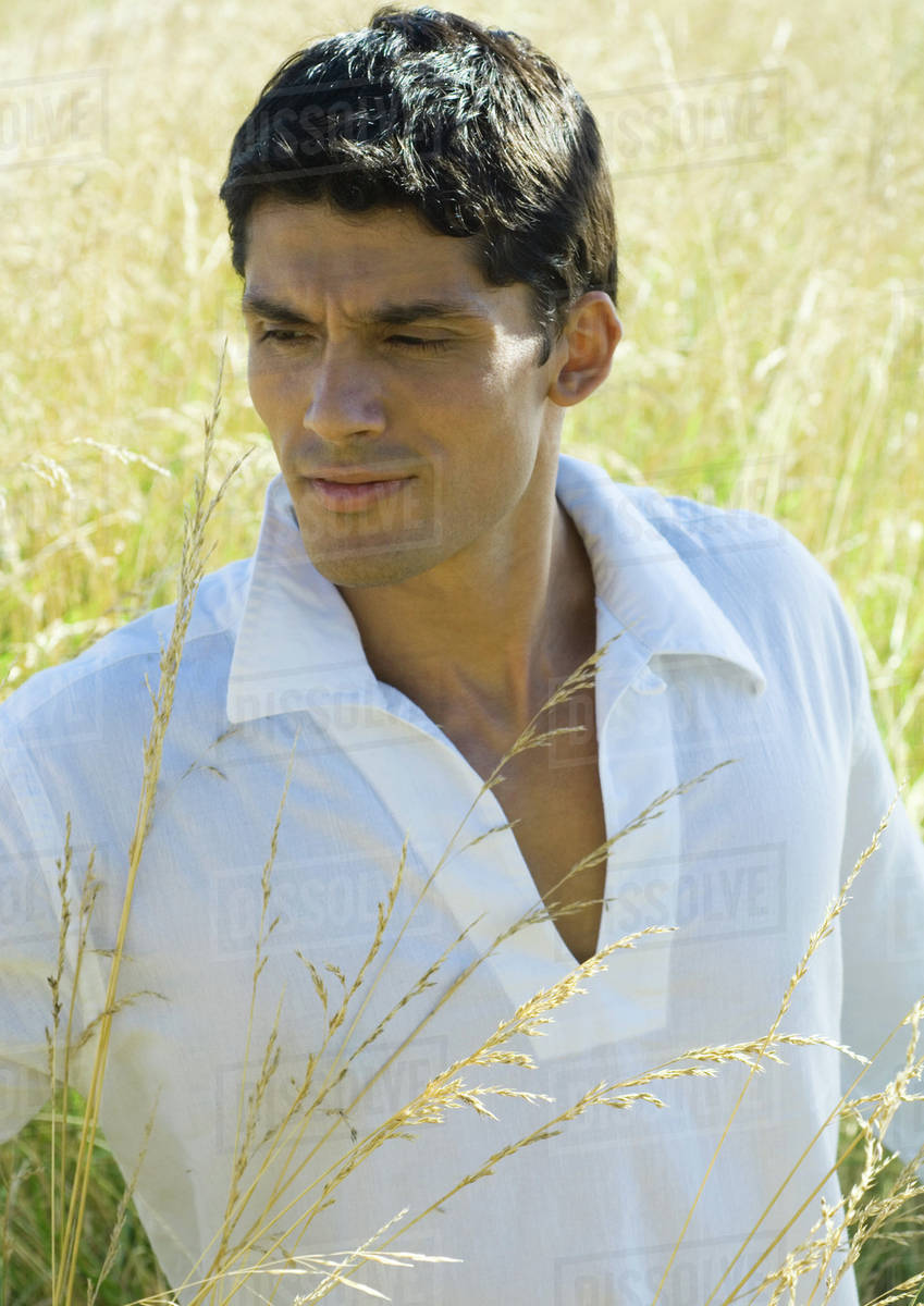 Man standing in field, portrait - Royalty-free Stock Photo | Dissolve