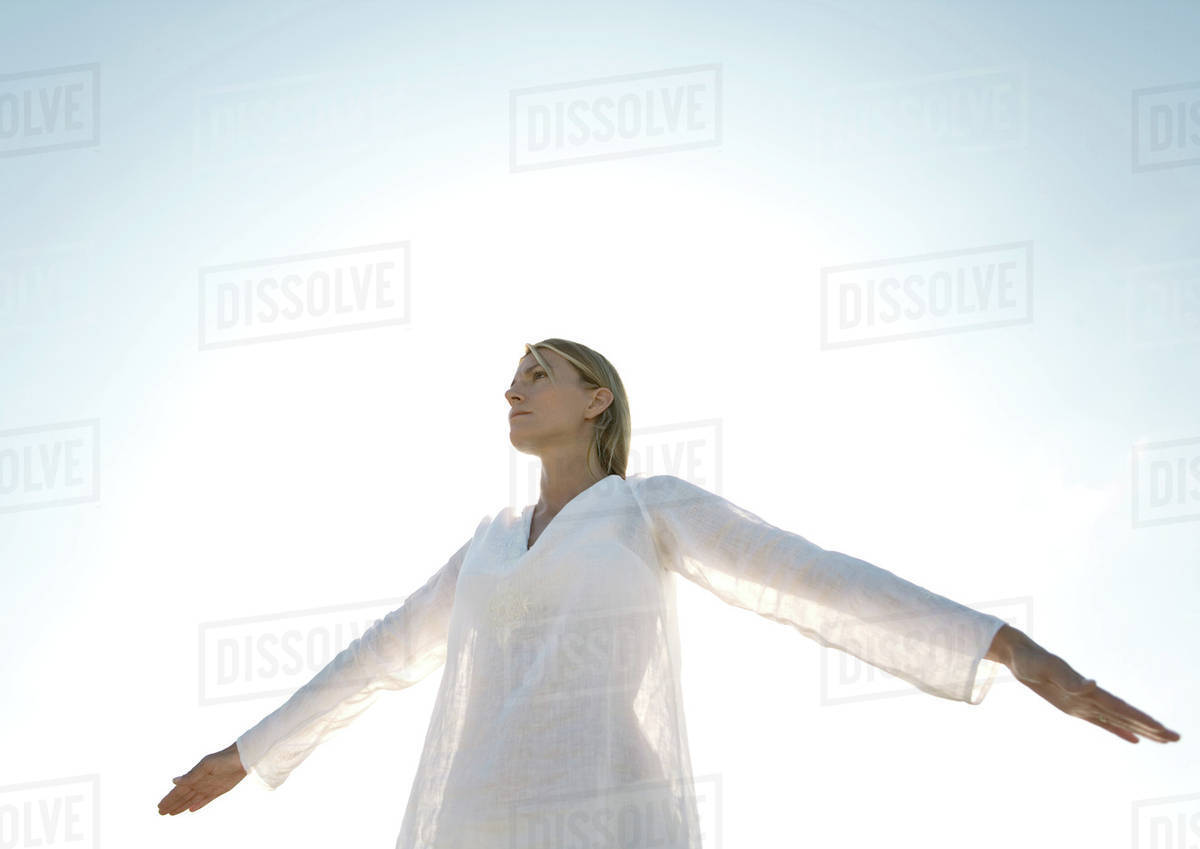 Man standing in field with arms out - Royalty-free Stock Photo | Dissolve