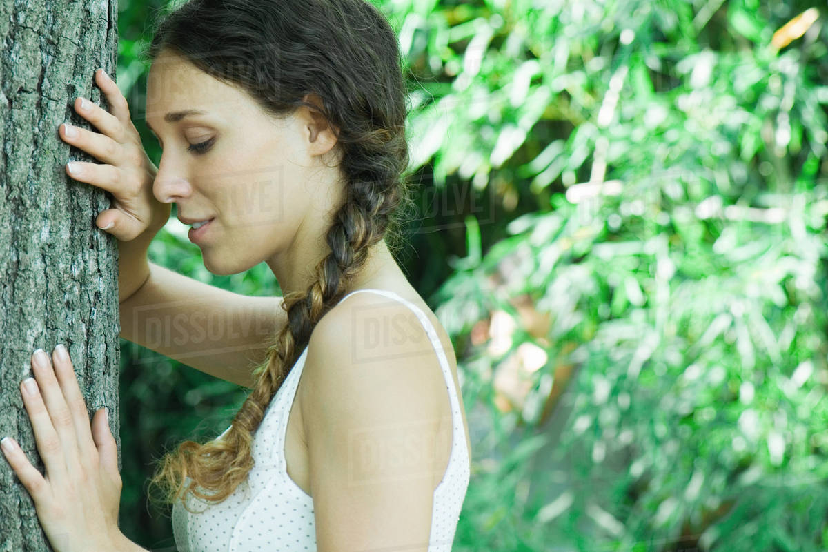 Woman touching tree trunk - Stock Photo - Dissolve