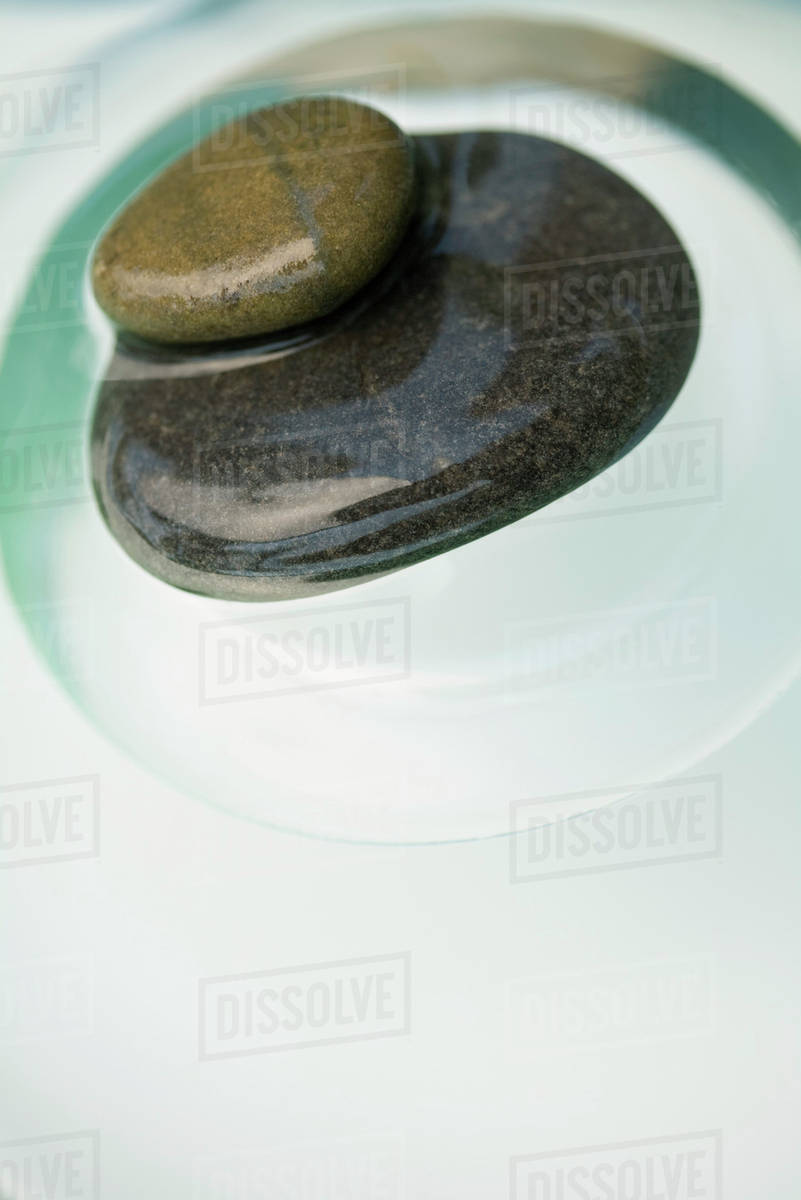 Two stones stacked one on the other, partially submerged in water ...