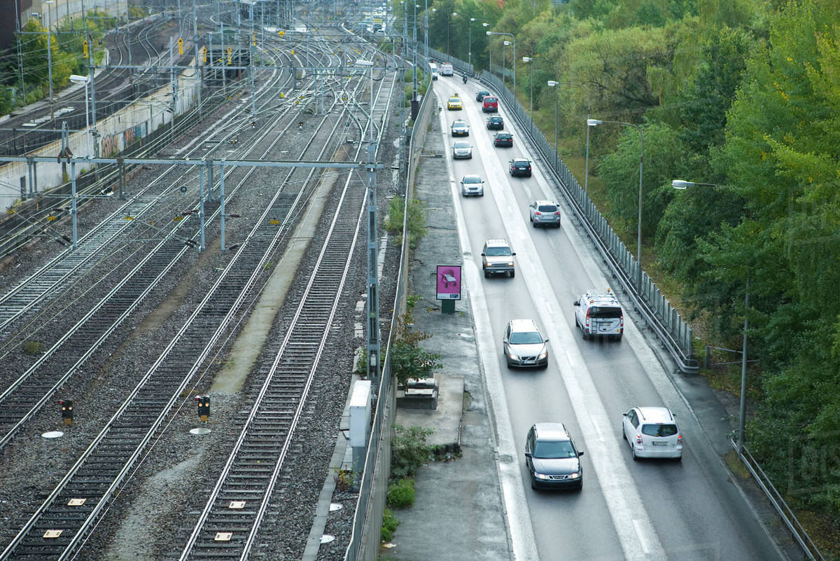 Sweden, Sodermanland, Stockholm, train tracks and street side by side ...
